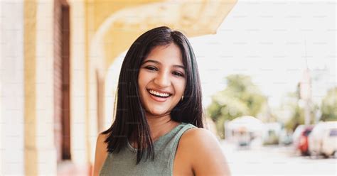 카메라를 보고 웃고 있는 젊은 라틴 아메리카 여성의 초상화 사진 Unsplash의 개념 이미지