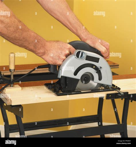 Handheld Electrical Circular Saw Cutting Through A Wood Plank Side View Stock Photo Alamy