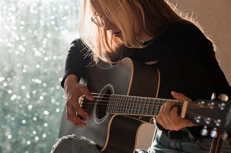 음악과 취미 재능있는 젊은 음악가 소녀는 혼자 앉아서 기타로 노래를 작곡합니다 소녀는 악기로 차분한 멜로디를 연주합니다 12 13세에 대한 스톡 사진 및 기타 이미지