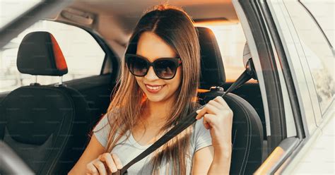 선글라스를 낀 여자가 차에 안전벨트를 매고 있다 사진 Unsplash의 행복 이미지