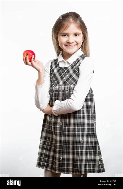 Portrait Of Cute Schoolgirl Holding Red Apple Against White Background