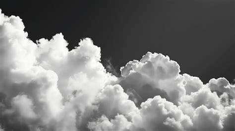 Black And White Photo Of Fluffy White Clouds Against A Dark Sky