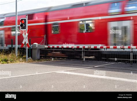 A Passenger Train Passing Through A Guarded Railway Crossing With