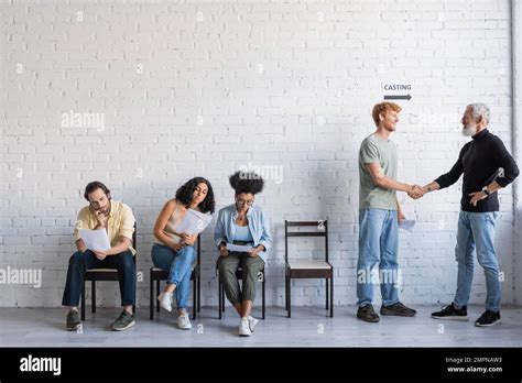 Bearded Producer Shaking Hands With Redhead Man Near Interracial Actors Translation Of Tattoo