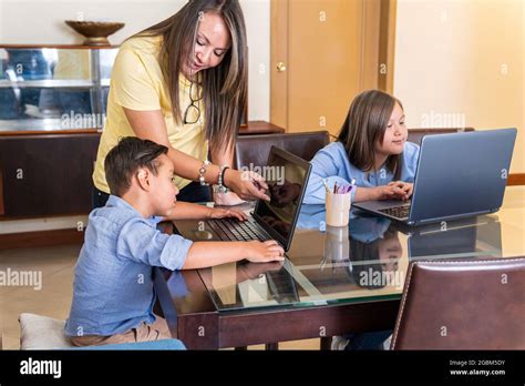 Latina Mutter Hilft Ihrem Sohn Mit Hausaufgaben Auf Einem Laptop W Hrend Ihre Tochter Zu Hause
