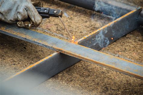 용접기 착용 보호 손 장갑 들고 전극 이며 용접 금속 및 스파크 용접은 제조 또는 재료 일반적으로 금속 또는 소성 조인 조각 과정입니다 강철에 대한 스톡 사진 및 기타