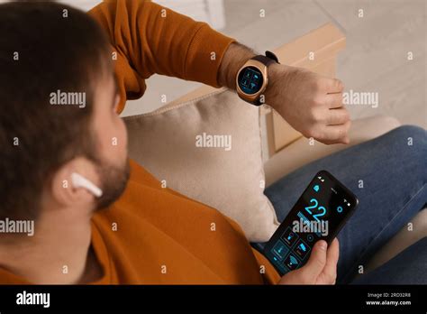 Man Setting Smart Home Control System Via Smartwatch And Mobile Phone