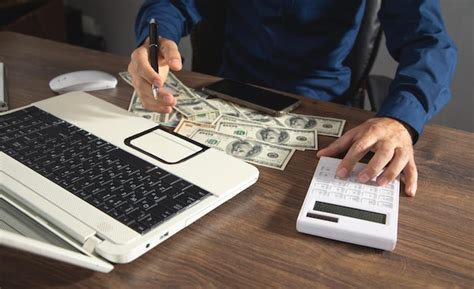 Premium Photo Man Using Calculator With A Money And Computer On The Table