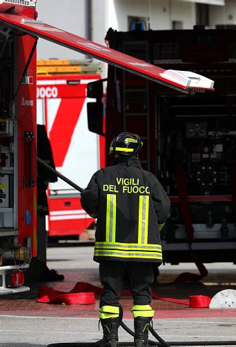 제복을 입은 이탈리아 소방관이 응급 장비를 들고 작업 중인 빨간색 소방차 옆에 서 있습니다 2명에 대한 스톡 사진 및 기타 이미지 Istock