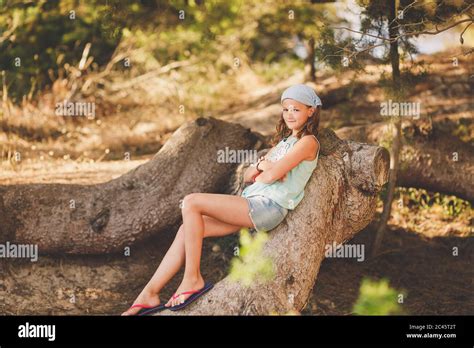Fille Assise Sur Un Tronc D Arbre En Banque De Photographies Et Dimages Haute R Solution Alamy