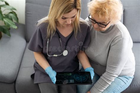 Shot Of A Young Doctor Holding A Tablet And Talking To Her Patient
