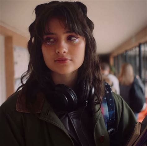 A Woman With Headphones On Looking At The Camera