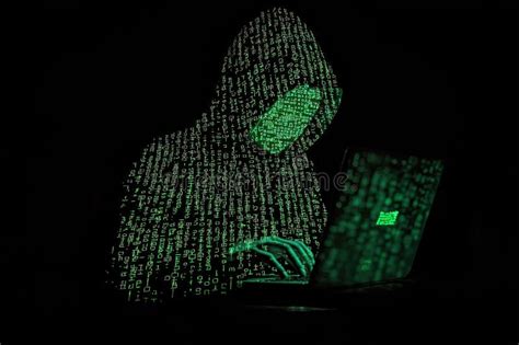 Hacker In Dark Room With Hoodie Typing On Laptop Surrounded By Digital