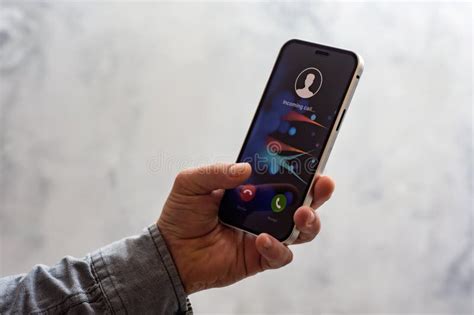 Close Up Of A Hand Holding A Smartphone With An Incoming Call Screen Display Shows Incoming