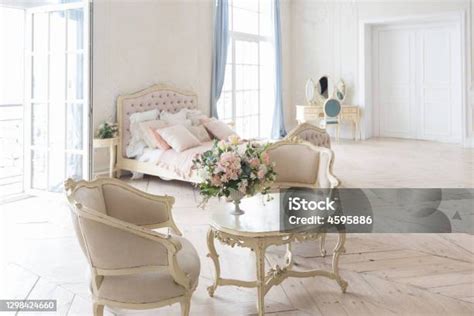 바로크 양식의 고급스러운 밝은 인테리어 도로 세련된 아름다운 가구 벽난로 꽃이 있는 넓은 객실입니다 벽과 가벼운 나무 마루에 식물 치장 벽토 0명에 대한 스톡 사진 및 기타