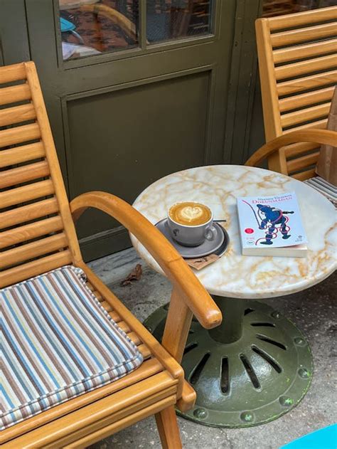 커피와 책이 있는 아늑한 야외 카페 풍경 · 무료 스톡 사진