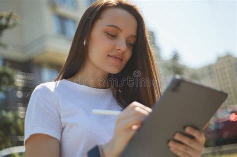 Beautiful Young Woman Drawing With A Stylus Pen On A Tablet Computer Portrait Of A Graphic