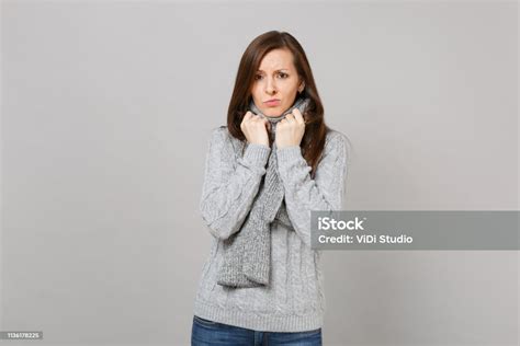 회색 벽 배경 스튜디오 초상화에 고립 된 스카프에 손을 잡고 그레이 스웨터에 화가 젊은 여자 건강 한 패션 라이프 스타일 사람들은 진지한 감정 추운 계절 개념 복사 공간을