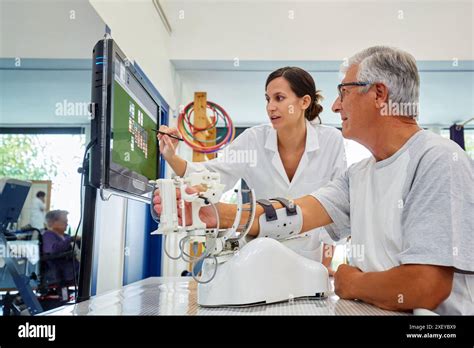 Therapist And Patient With Assistive Robot For Upper Limb