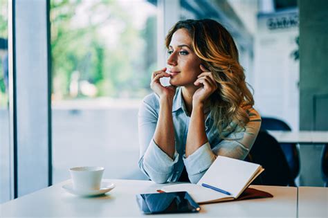 실내를 바라보면서 자유 시간을 즐기는 매력적인 펜싱 재능있는 학생 예쁜 힙스터 소녀 숙고 하는 동안 에 앉아 나무 테이블에