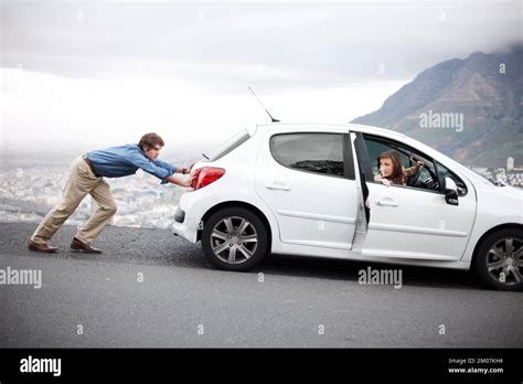 Just Keep Pushing Young Man Pushing The Car While His Wife Tries To Start It Vehicle