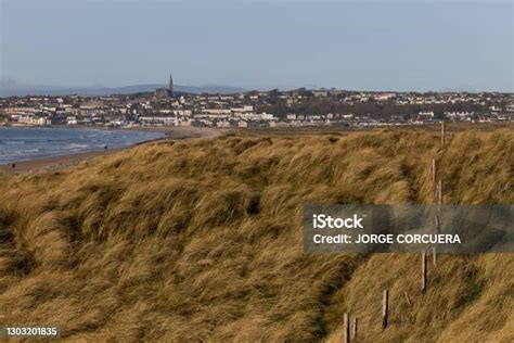 산 꼭대기에 가톨릭 교회와 배경에 도시와 모래 언덕과 잔디와 울타리 트라모어 자연 보호 구역 워터 포드 아일랜드 0명에 대한 스톡 사진 및 기타 이미지 Istock
