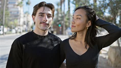Interracial Couple With A Hispanic Man And Asian Woman Embracing On An