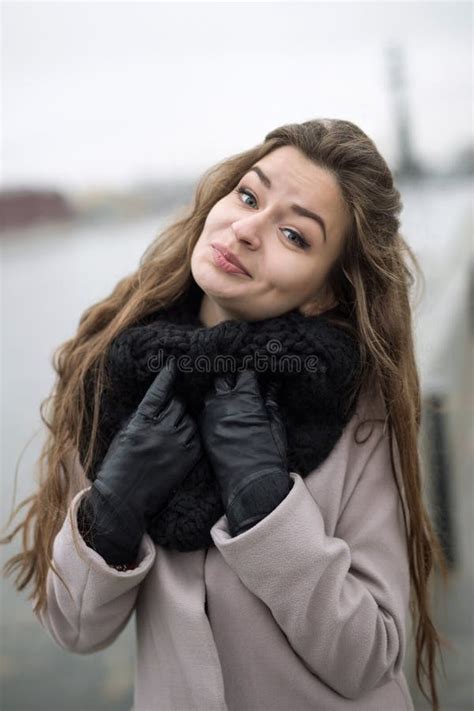 Красивая девушка в усмехаться естественного состава милый на камере Девушка в черном пальто