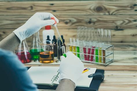 Premium Photo Midsection Of Scientist Performing Scientific Experiment At Laboratory