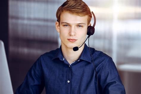 Premium Photo Young Blond Businessman Using Headset And Computer In A