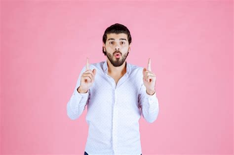 Free Photo Man In A White Shirt Pointing At Something Above