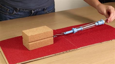 A Wooden Block Is Dragged Across Sandpaper Using A Spring Scale
