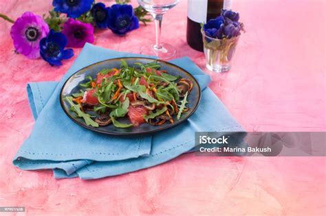Arugula 연어 샐러드 소스와 자 몽 옷 와인의 유리입니다 낭만적인 저녁 식사 및 꽃입니다 카드입니다 핑크 배경입니다 복사 공간 0명에 대한 스톡 사진 및 기타 이미지