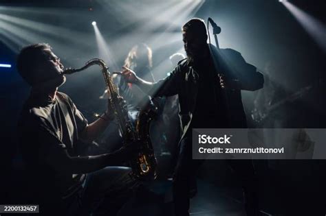 무대 조명 아래에서 활기차게 공연하는 색소폰 연주자와 가수 20 29세에 대한 스톡 사진 및 기타 이미지 20 29세 25 29세 30 39세 Istock