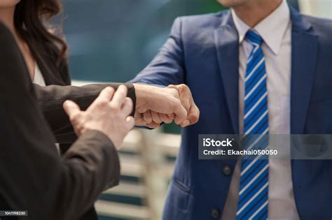 가까이 실업가 주먹을 만들기의 배경에서 젊은 여자와 건물에 밤 비즈니스 사람들이 착용 정장 좋은 거래 후 주먹 펌프에 함께 할 비즈니스 성공 및 팀워크 개념입니다 개념에