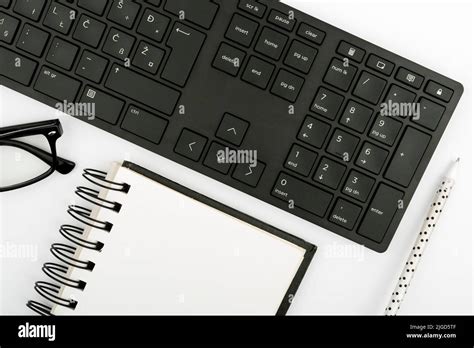 A Top View Of Computer Keyboard Notes And Glasses On A White