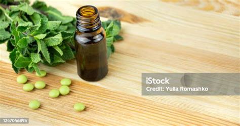 페퍼민트 오일은 나무 테이블에 신선한 민트 잎이 있는 유리 병에 담겨 있습니다 공간을 복사합니다 건강관리와 의술에 대한 스톡 사진 및 기타 이미지 Istock
