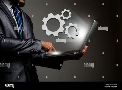 Businessman Holds Laptop With Setting Symbol Icon Stock Photo Alamy