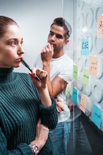스티커 메모와 함께 유리 벽 뒤에 사무실 공간에 서 있는 동료 들의 초상화 팀 관리자 Disscusing 및 새로운 Sturtup 아이디어를 브레인 스토밍 2명에 대한 스톡