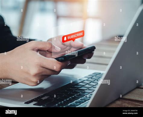 Subscription Concept Red Subscribe Button With Bell Icon Appear On Smart Mobile Phone In Hands