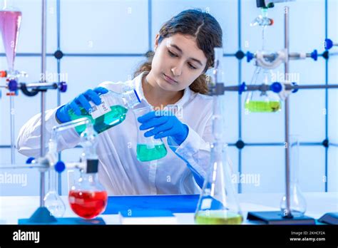 Young Adult Female Scientist Conducts A Chemical Experiment In A
