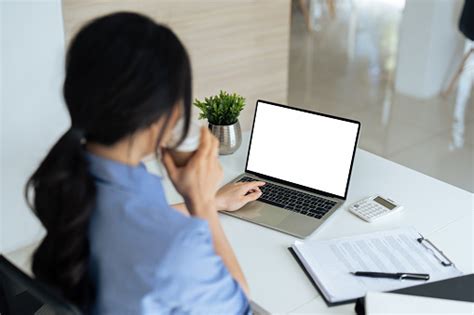 젊은 여성 사업가들은 노트북에 타이핑을 하고 사무실 책상에서 커피를 마신다 빈 화면 노트북에 대한 스톡 사진 및 기타 이미지 노트북 여자 일함 Istock