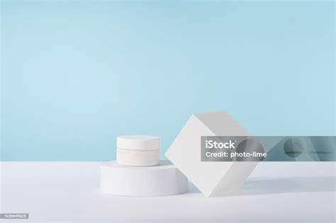 화장품 고급 크림 항아리 병 모형은 받침대 연단에 파란색 배경에 있습니다 브랜드가없는 로션 미용 제품 포장 제품 프레젠테이션