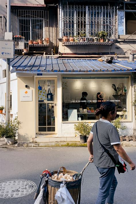 낮 동안 가게 앞에 서 있는 흑백 줄무늬 셔츠를 입은 여자 사진 Unsplash의 무료 锦都3期 이미지