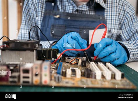 Closeup Hands Of Female Technician Measuring Electrical Voltage Of Computer Mainboard By Using