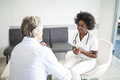 Médico Consultando Al Paciente En La Sala De Espera Del Hospital