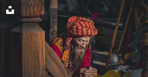 긴 턱수염과 긴 턱수염을 가진 남자가 빨간색과 노란색 모자를 쓰고 있습니다 사진 Unsplash의 무료 색 이미지