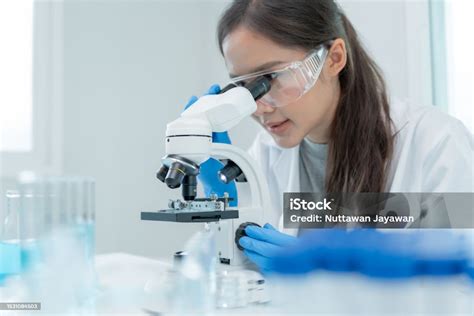 과학자는 첨단 과학 실험실에서 생화학 샘플을 분석합니다 의료 전문 사용 현미경은 바이러스의 미생물 학적 발달을 보입니다 과학