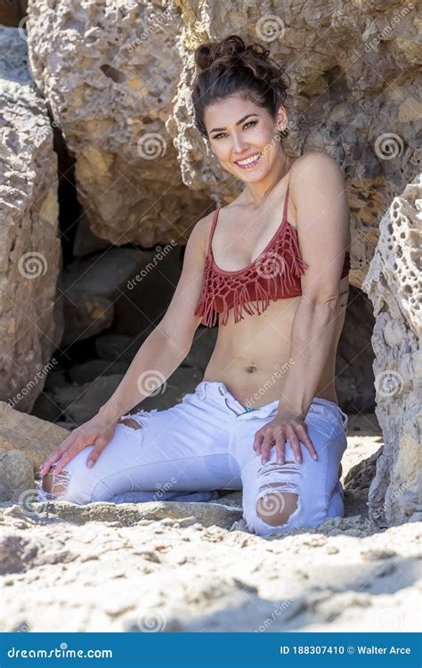 Lovely Brunette Bikini Model Relaxing On The Shoreline At The Beach