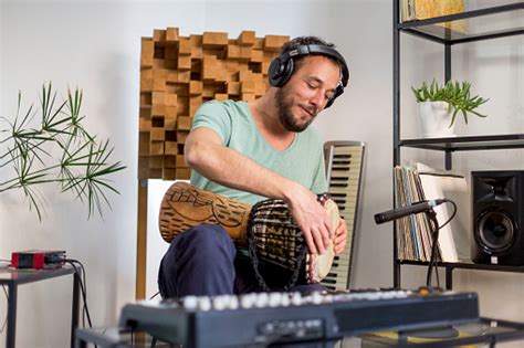 집에서 디지털 스튜디오에서 젬 베 드럼 악기를 녹음 전문 음악가 그는 악기와 Midi 컨트롤러로 둘러싸여 있습니다 음악 제작 컨셉 개념에 대한 스톡 사진 및 기타 이미지